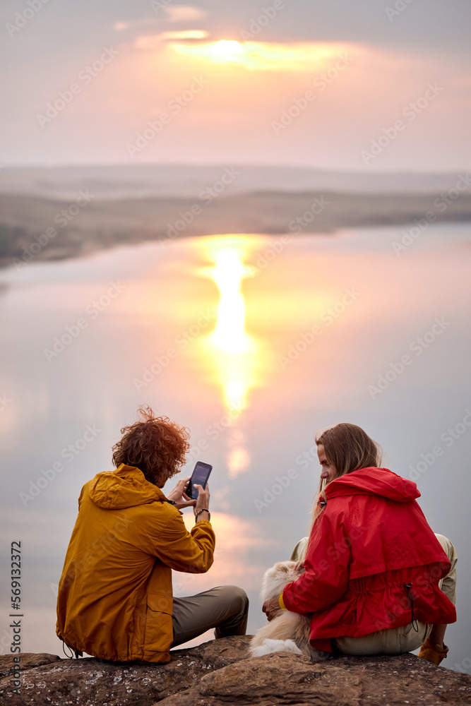 Outdoor shot of young couple enjoying on their hiking trip, walking ...