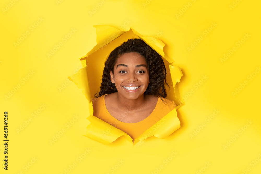 Portrait of black woman posing in torn paper looking at camera and ...