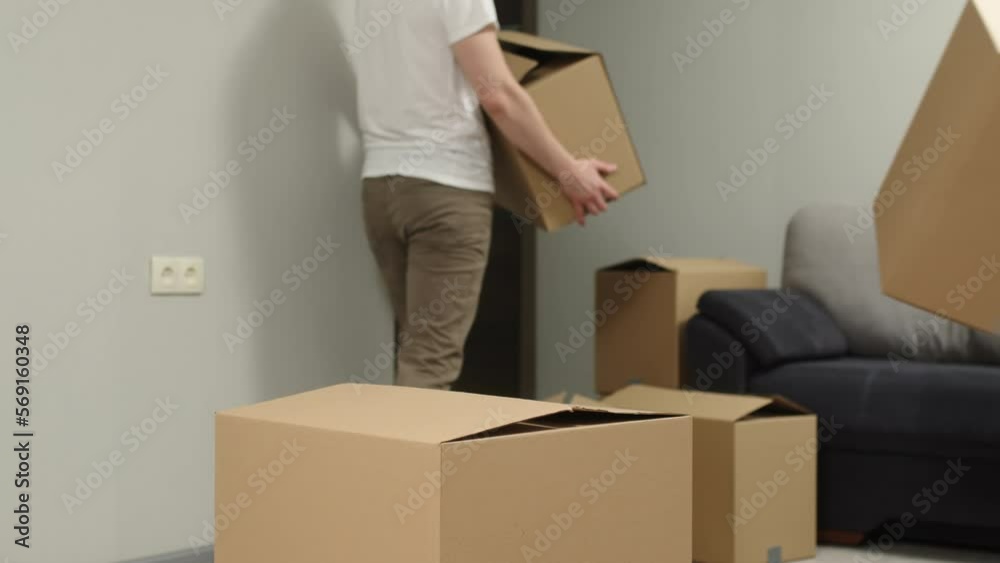 Portrait of a little girl jumping out of a cardboard box with mom and ...