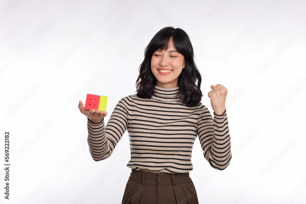 Asian woman holding a rubik cube standing on white background. solving ...