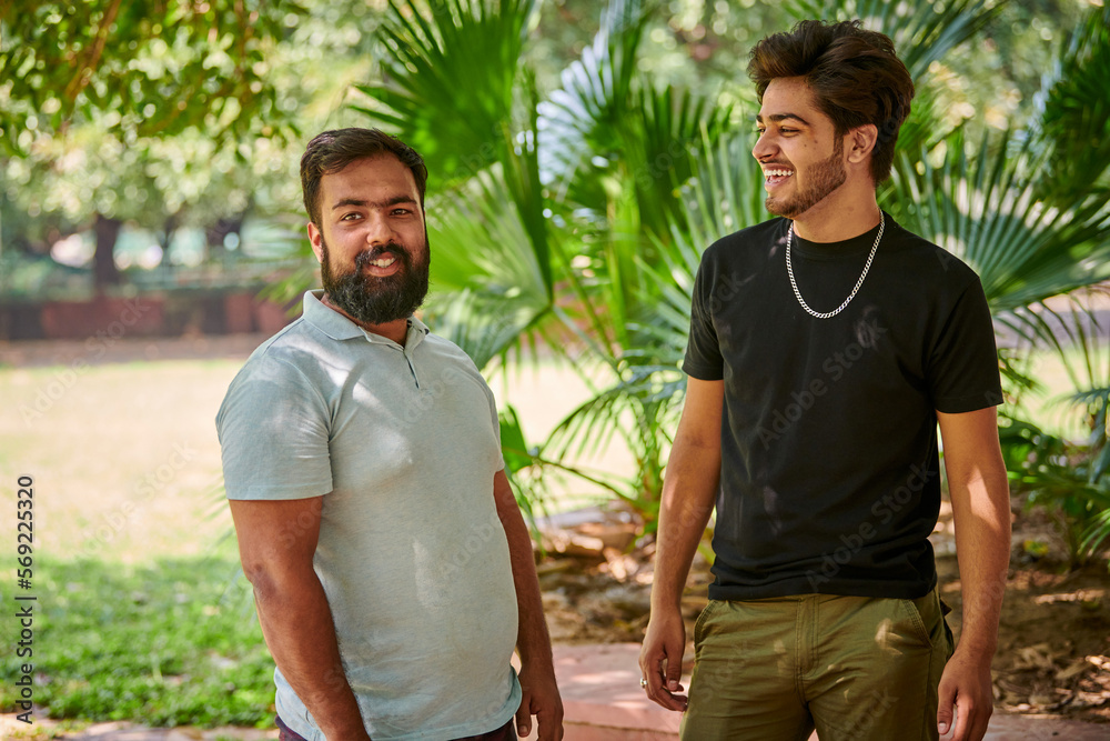 Two funny indian men laughing and speak Hindi in public park green palm ...