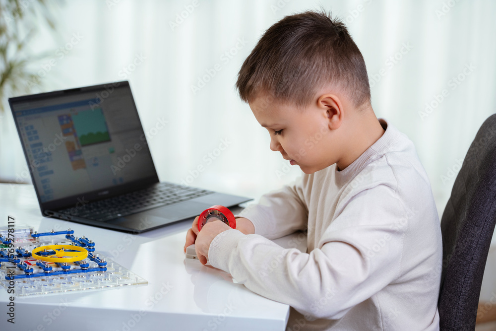 School boy remotely learn online at home in coding robot and electronic ...