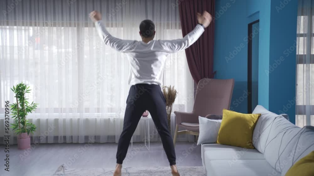Young fit man doing jumping exercise at home. Young man is exercising ...