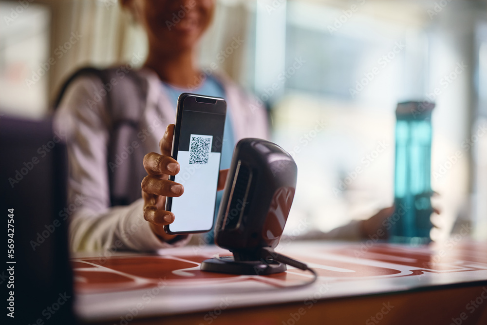 Close up of athlete scanning QR code on mobile phone while checking in ...