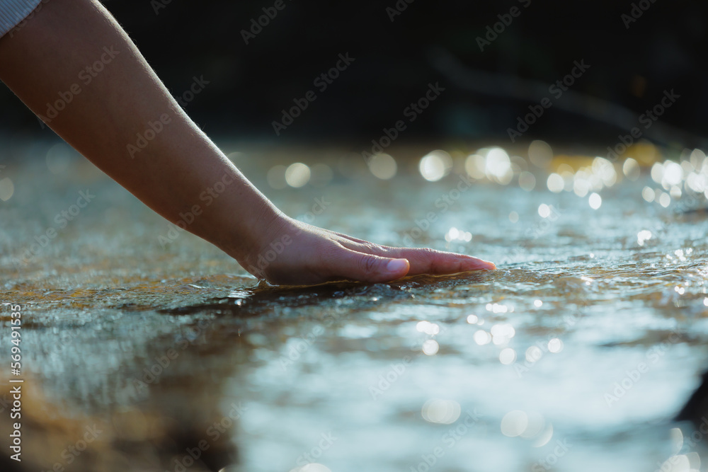 Foto de Hand touching the surface of water in the river at the morning ...
