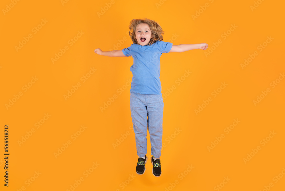 Full length of excited kid jumping. Energetic kid boy jumping and ...