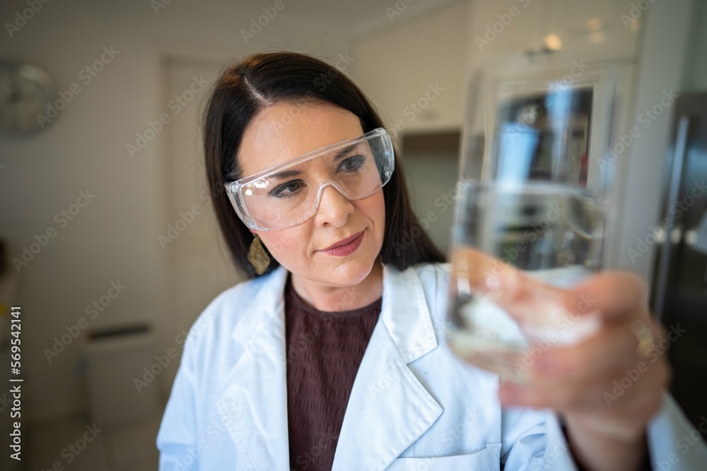 Girl studying a soil and plant sample in field. scientist in a paddock ...