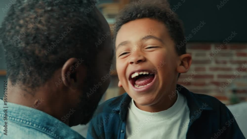 Back view happy adult African American dad talk with preschool child ...