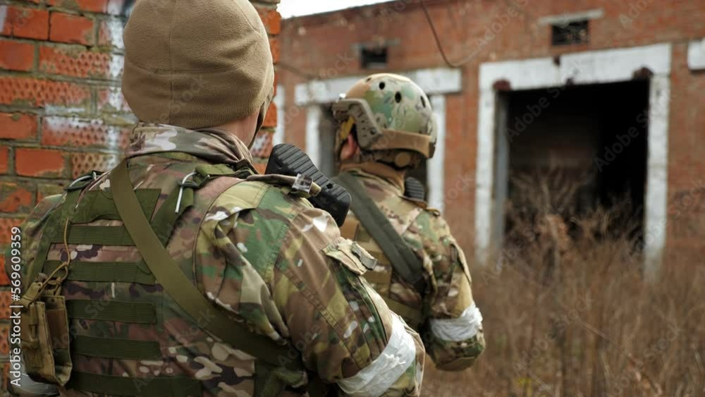 Two men in military camouflage uniforms with automatic rifles with ...