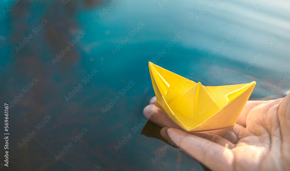 Yellow lonely floating paper boat in hand. Colorful sailing ship in big ...