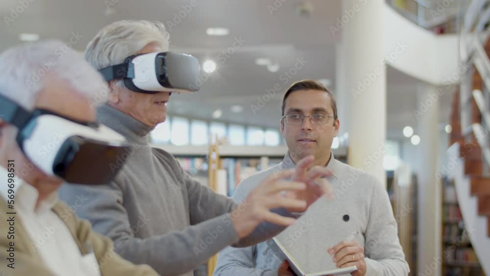 Elderly people in VR glasses in library with teacher. Side view of ...
