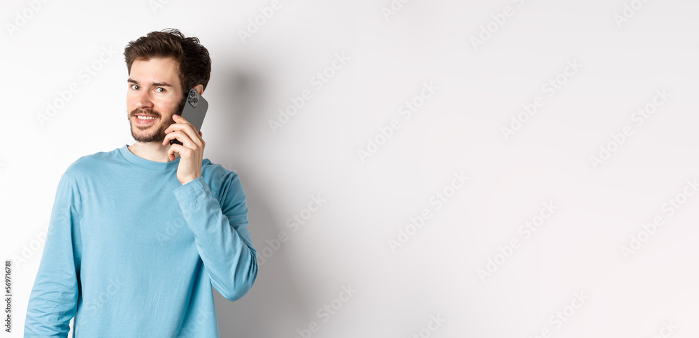 Technology concept. Young male model talking on mobile phone, calling ...