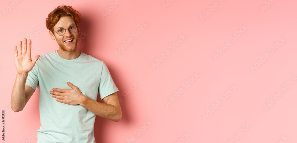 Friendly redhead man being honest, holding hand on heart and arm raised ...