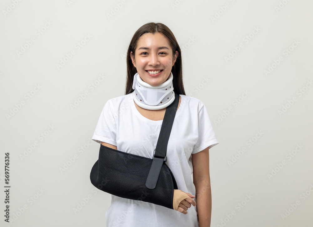 Happy young asian woman broken arm on isolated background. Asian female put on plaster bandage ...