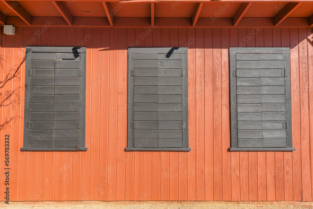 Vertical wood wall cladding with three closed painted wooden window ...