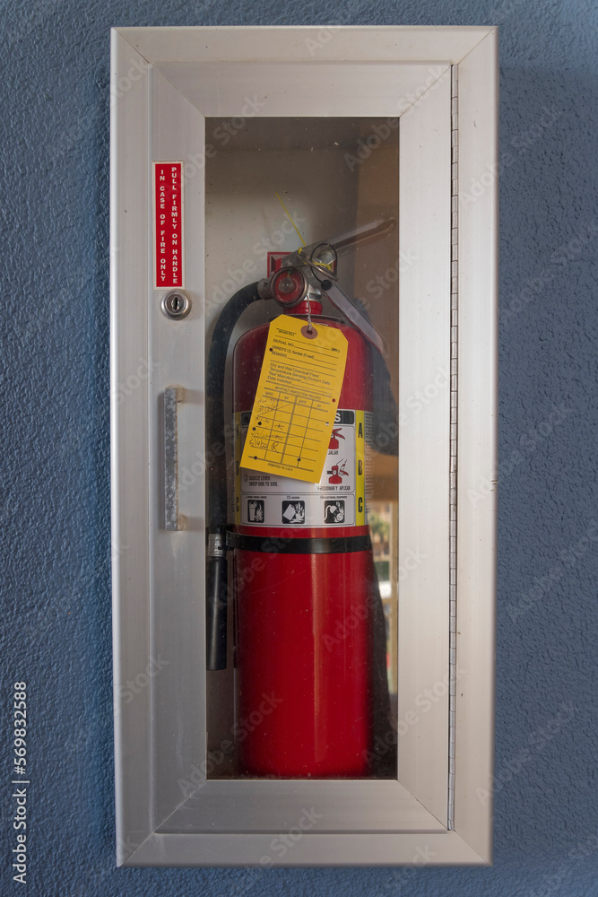Fire extinguisher inside a cabinet with glass and aluminum frame on a ...