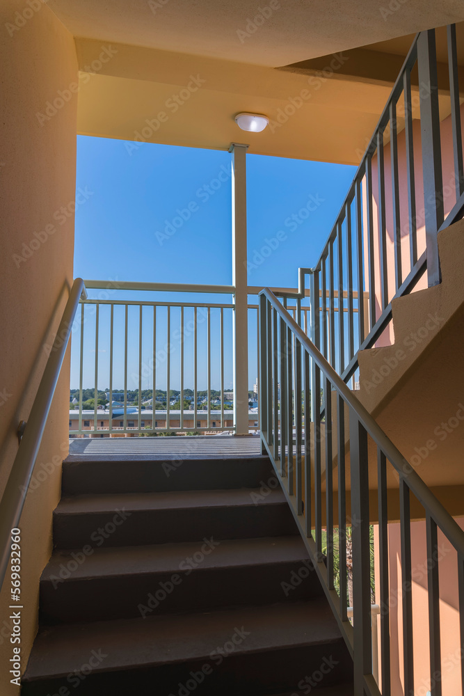 Stairwell with natural daylight from a landing with railings and ...