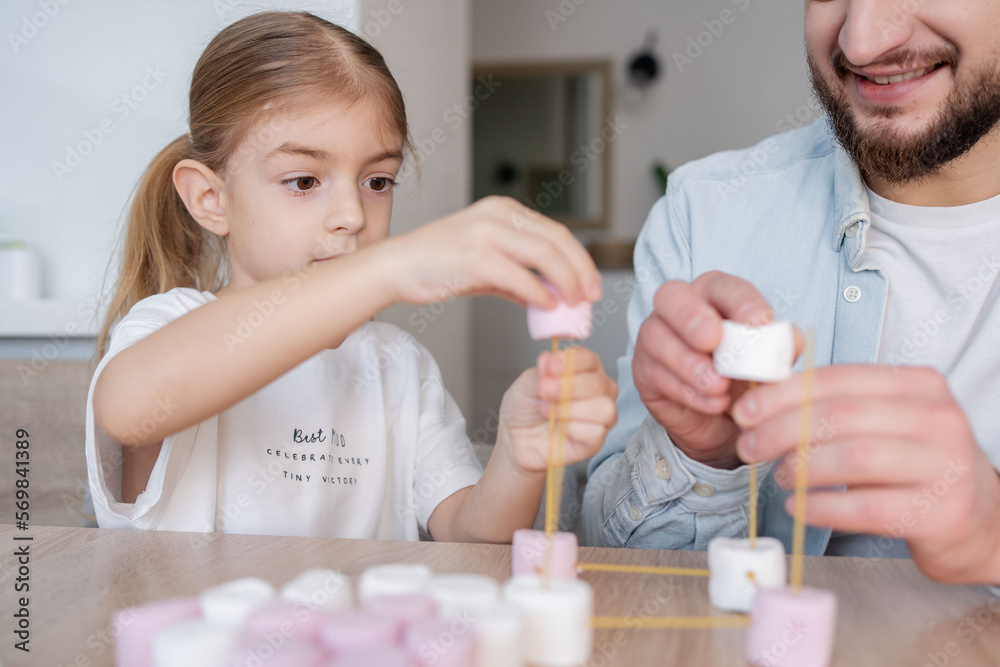 little girl with father constructs a model of a molecule and conducts ...