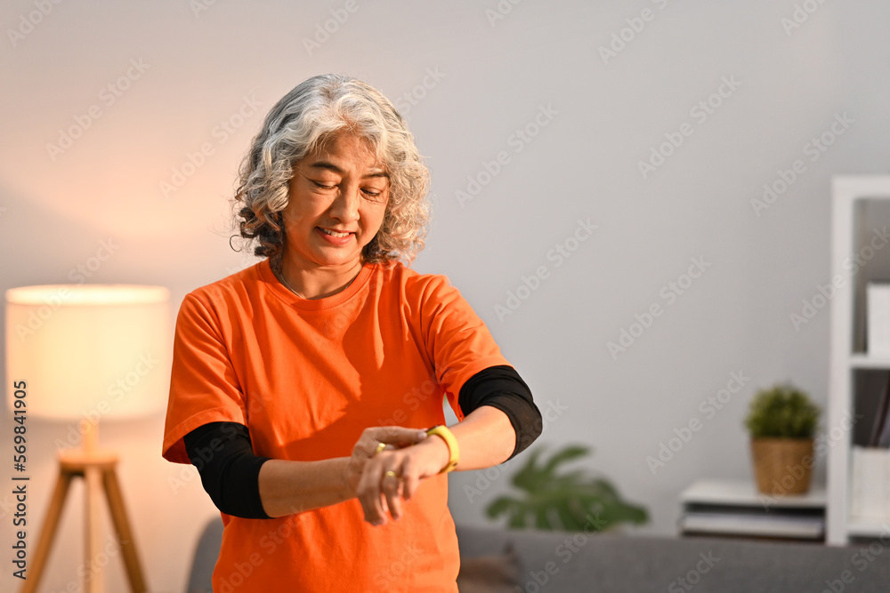 Foto de Pleasant middle aged woman checking her heart rate data on ...