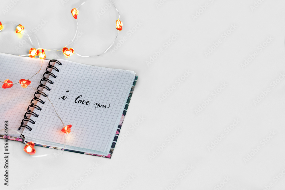 I love you romantic note in notepad covered with a heart-shaped light ...