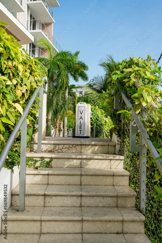 Concrete stairs with gray concrete handrails leading to the Valet sign ...