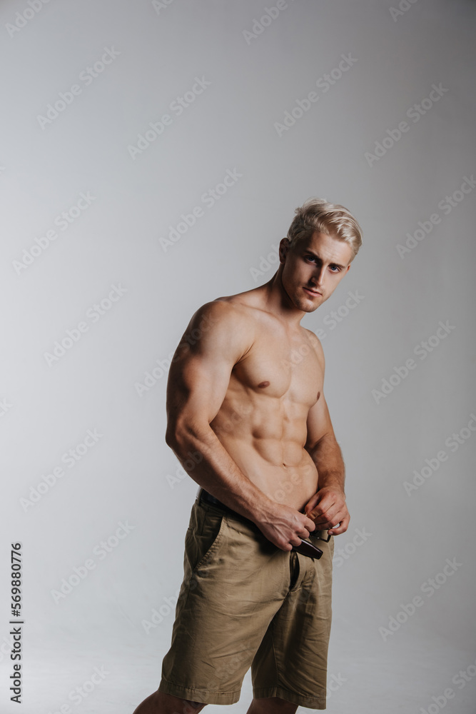 Handsome male model wearing sand pants. Sexy shirtless man in studio ...