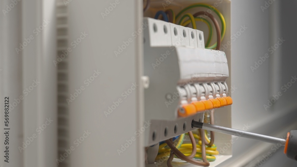 Electrician assembles electrical panel. Close up of a man hands ...