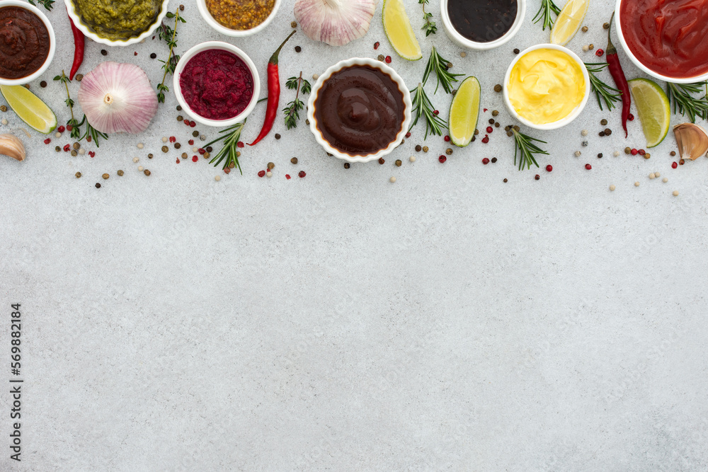 Different types of sauces in bowls with seasonings, rosemary and pepper ...