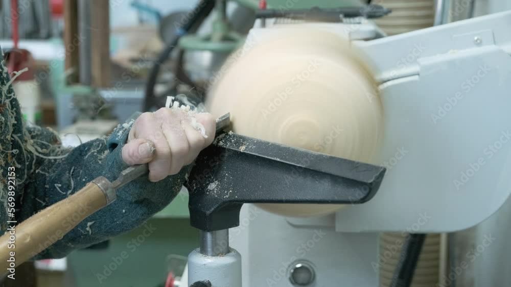 Woodturning on a wood turning lathe. Carpenter shaping a piece of wood ...