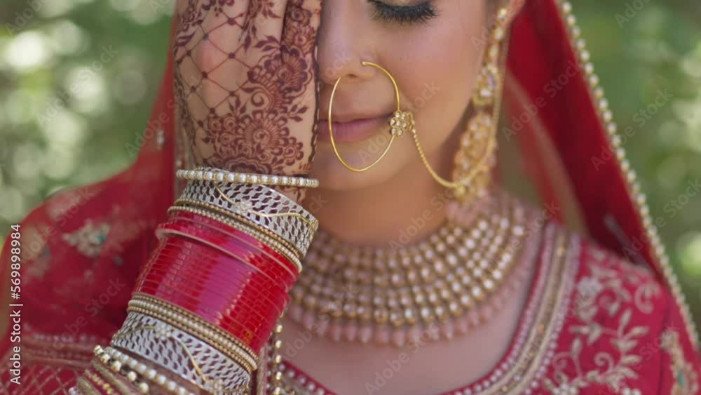 Portrait of a happy Indian bride covering her face with her hand, Hindi ...