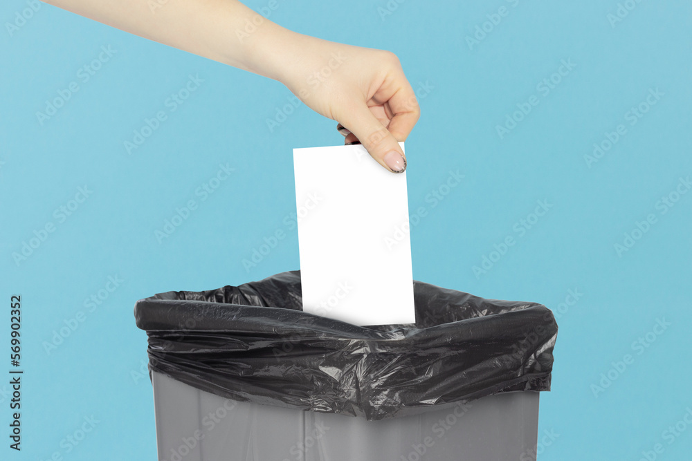 business card in an outstretched hand over a trash can, space for text ...