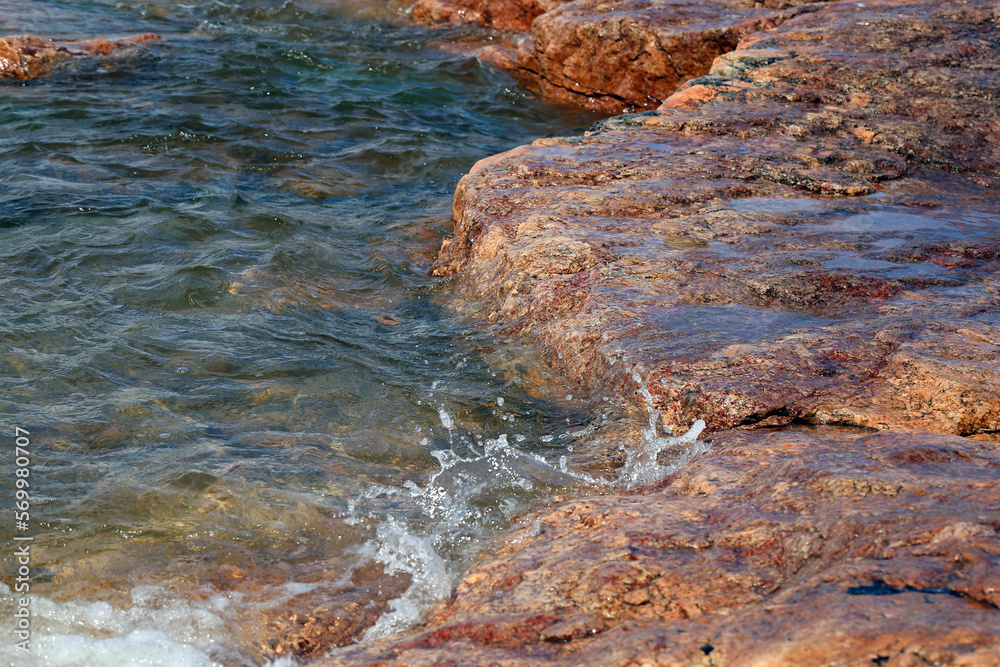 Foto de Lots of small waves hitting red and black beach rocks in Eira ...