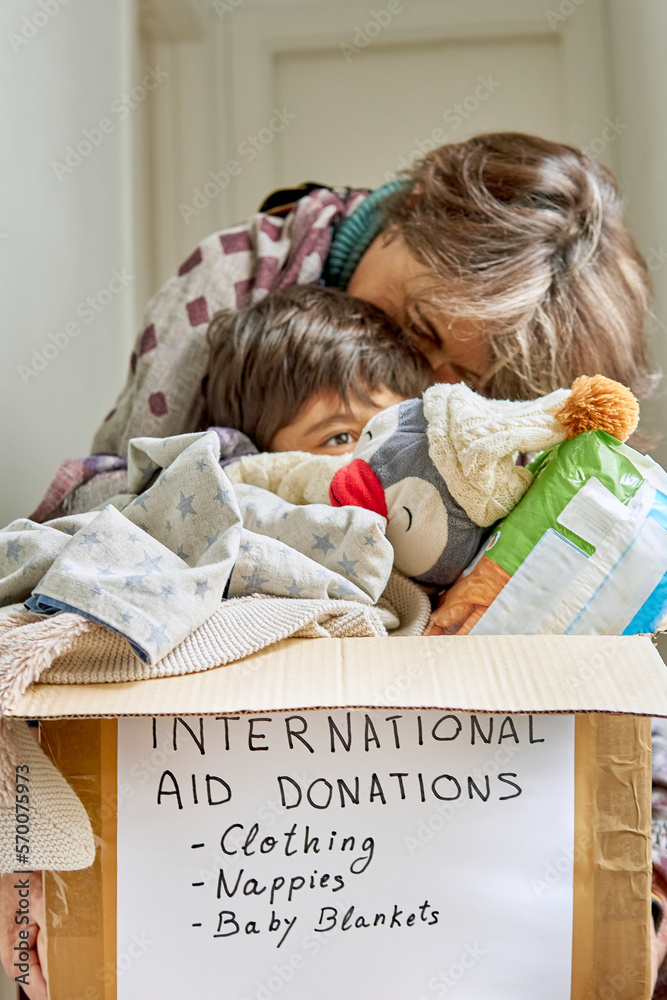 Grandmother and grandchild supporting a box with humanitarian aid for a ...
