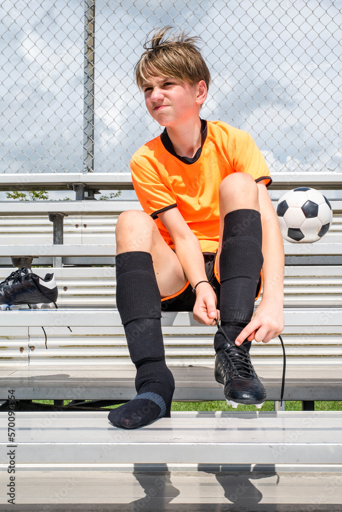 Youth soccer player having trouble tying his cleats Stock Photo | Adobe ...