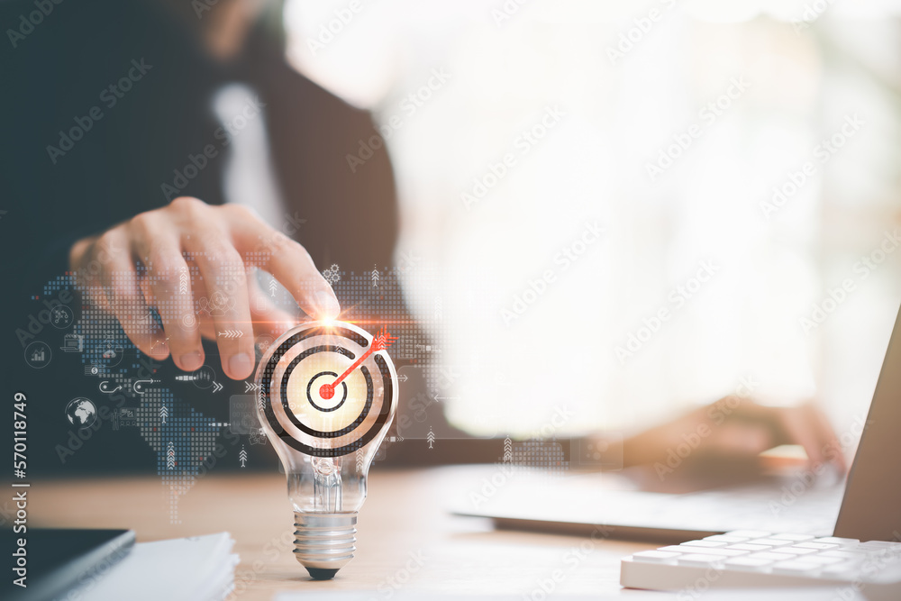 businessman pointing to a light bulb and arrow icon hitting center of ...