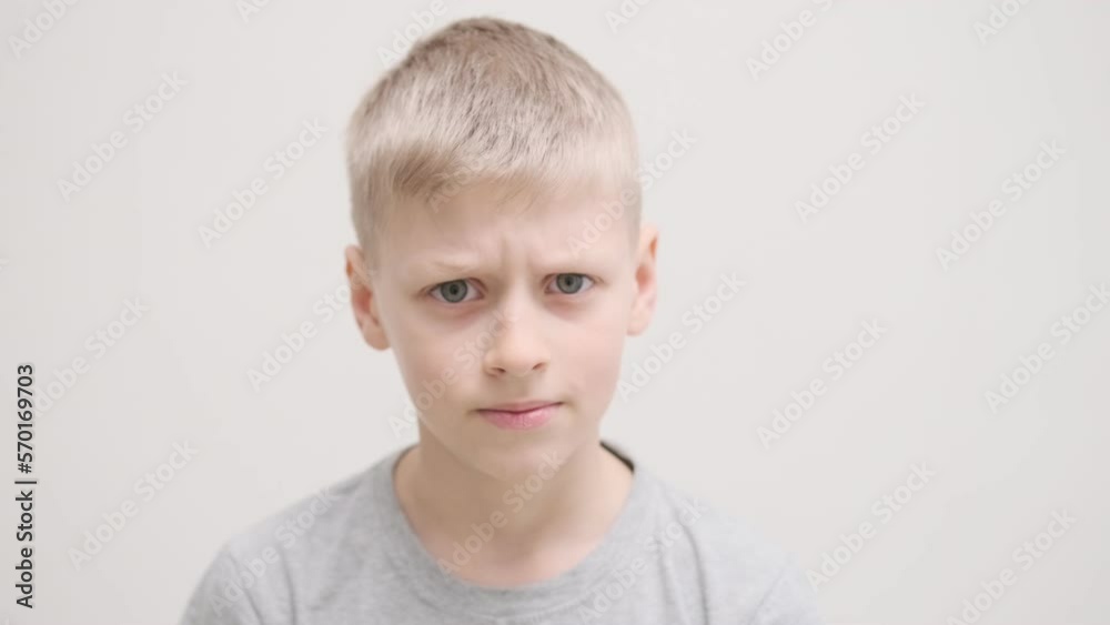 Frowning unhappy young caucasian child looking angry at camera. Upset ...