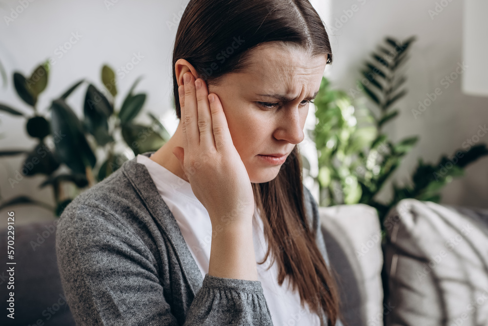 Close up portrait of upset young girl holding painful ear, suddenly ...