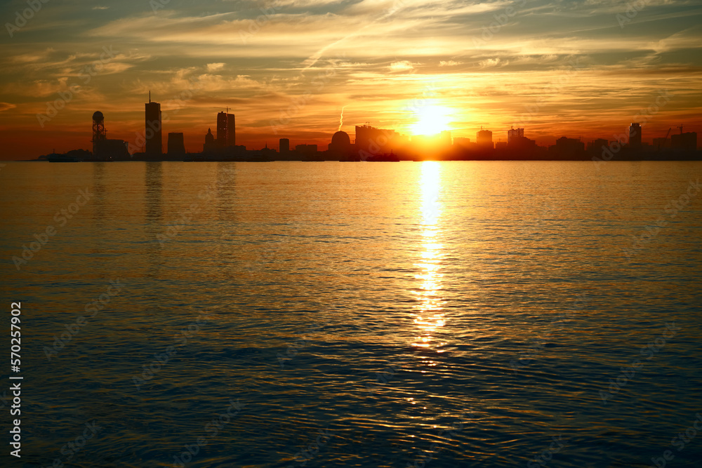 yellow Sunset view of the city line with reflections on the water ...