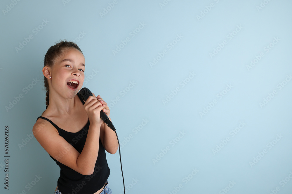 Portrait of a cute teenage girl singing, using microphone. Teenage girl ...