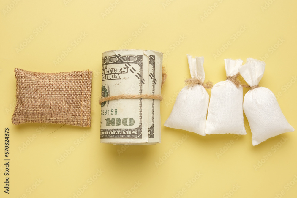 A picture of roll fake money with 3 flour bag and wheat bag on yellow ...