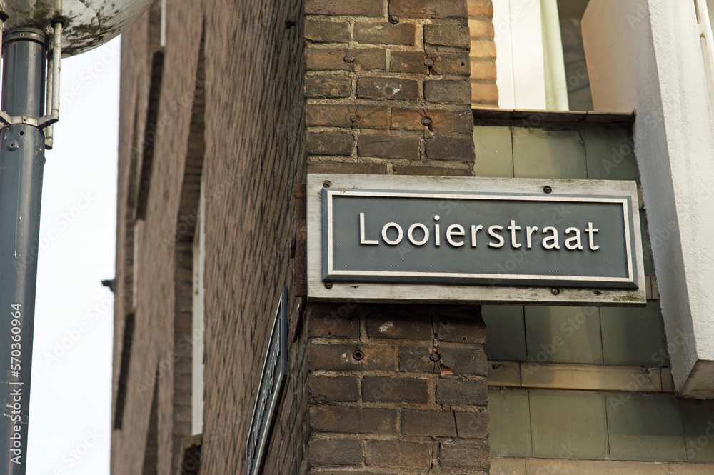Blue street name sign of Looierstraat on a brown stone wall in Arnhem ...