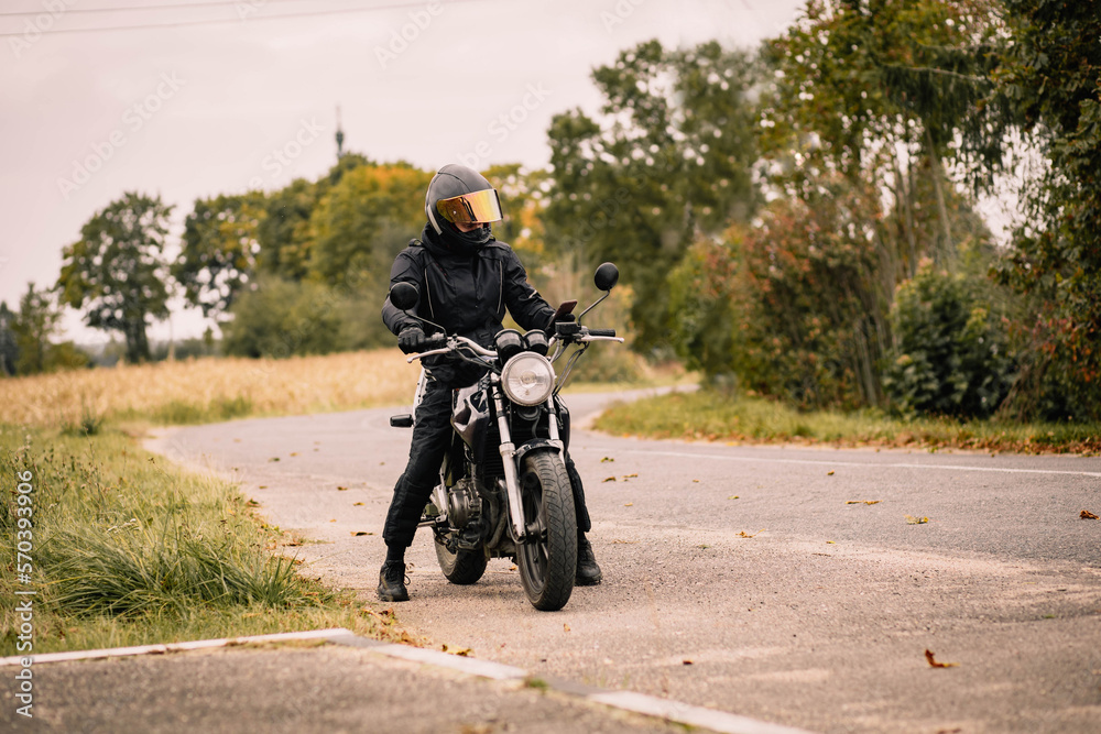 motorcyclist on a motorcycle in the spring in a helmet, retro cafe ...