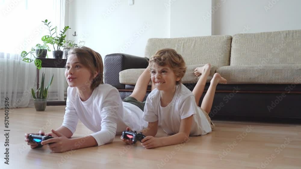 Gamer Children siblings playing video games in front of tv, using ...