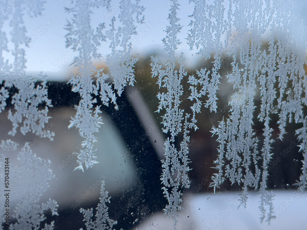 Frozen window with ice crystals forming in lines with snowflake ...