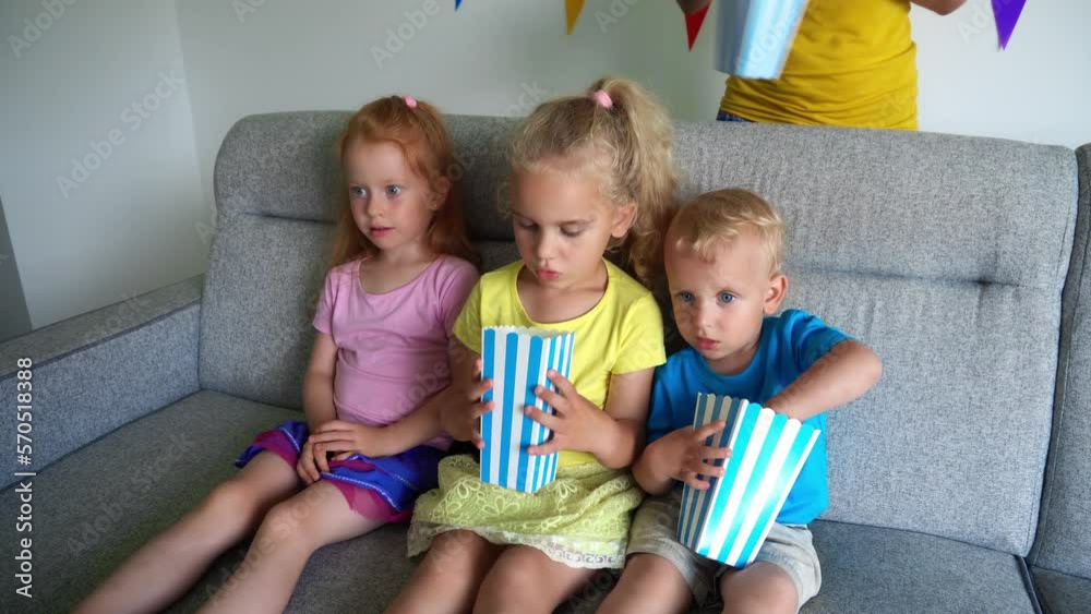 Mother hand give popcorn boxes for children watching tv television ...