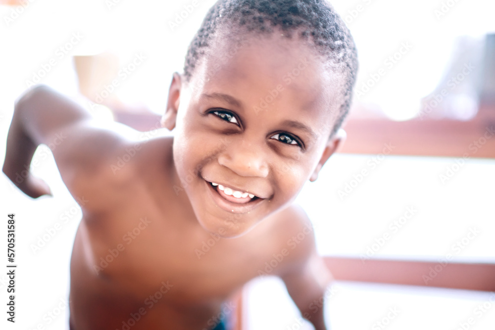 Nice little African child looking at camera and making funny gestures ...
