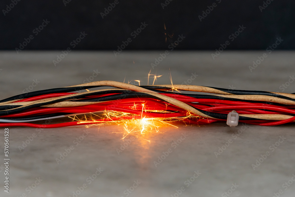 there is a fire burning in the electric wires, sparks fly on a dark ...