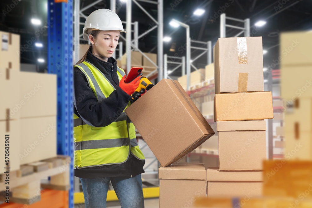 Woman works in warehouse. Girl with phone near racks and boxes. Woman ...