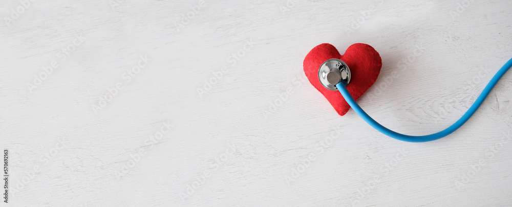 Heart soft toy and stethoscope on a light background. Children's first ...