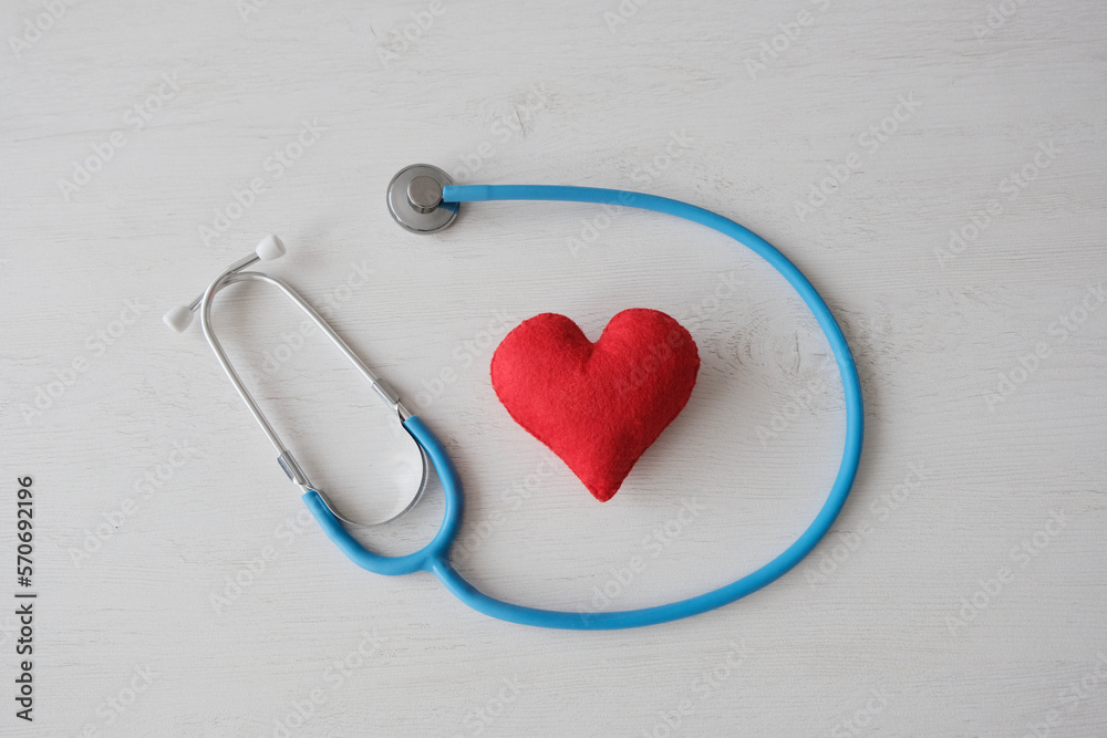 Heart soft toy and stethoscope on a light background. Children's first ...